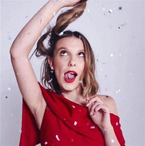 A Woman In A Red Dress Holding Her Hair Up