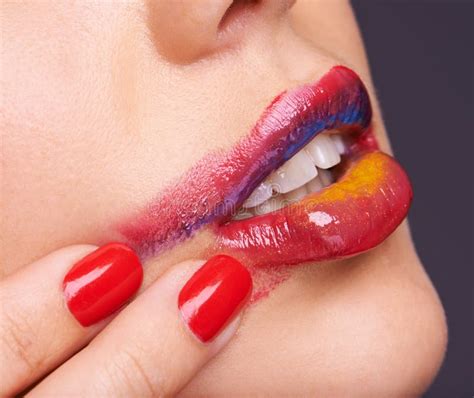 Tempting Tones A Woman Smearing The Multicolored Lipstick Off Of Her