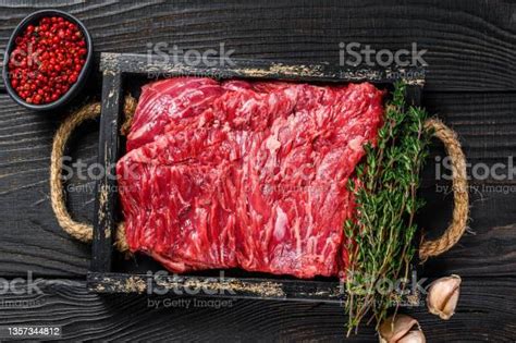 생 신선한 쇠고기 브리스킷은 나무 트레이에 허브로 고기를 잘라냅니다 검은 색 나무 배경 위쪽 보기 0명에 대한 스톡 사진 및