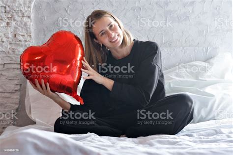 빨간 하트 모양의 풍선을 가진 소녀는 미소 지으며 인생을 즐깁니다 발렌타인 데이를 축하하는 백인 여성 남자 친구에게 보내는 메모 인간의 감정 표정 관계 낭만적 인 휴일의