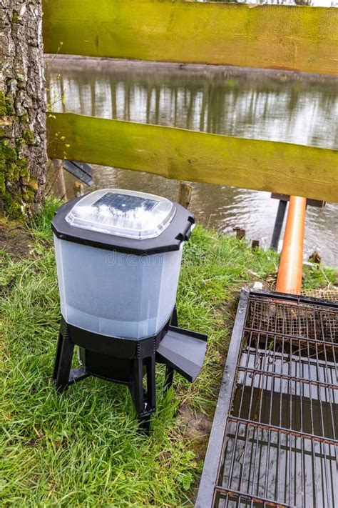 An Automatic Fish Feeder Stands At The Edge Of A Trout Pool Stock Photo
