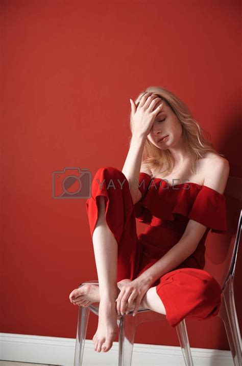 Beautiful Young Adult Woman Wearing Red Jumpsuit Relaxing On Chair By