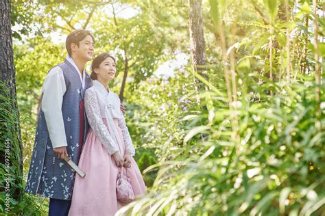 Foto De 한복을 입고 숲길 또는 공원을 걷고 있는 아름답고 멋진 젊은 아시아 한국 남녀 모델 Do Stock Adobe Stock