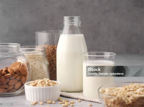 견과류 소나무 견과류 오트밀 쌀 메밀 아몬드 회색 배경에 안경을 쓴 코코넛에서 유기농 채식주의 자 비 유제품 우유의 구색 음료