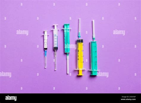 Top View Of Medical Syringes With Needles At Purple Background With