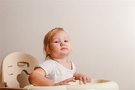 흰색 바디 수트에 귀여운 금발의 어린 소녀는 흰색 배경에 아기 의자에 앉아 18 23 개월에 대한 스톡 사진 및 기타 이미지 18 23 개월 가정 생활 건강한 생활