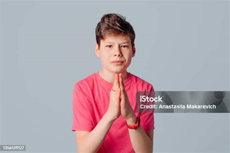 잘 생긴 십대 소년은 도움을 주셔서 감사합니다 감사하고 나마스테 제스처와 정중하게 절 가슴기도 기호 회색 배경 위에 함께 손을