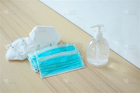 医用口罩与酒精消毒液凝胶洗手液放在木桌上以预防covid 19冠状病毒