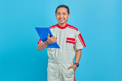 클립보드를 들고 파란 배경 위에 고립 된 카메라를보고 미소 잘 생긴 정비사 가리키기에 대한 스톡 사진 및 기타 이미지 가리키기 긍정적인 감정 표현 기계공 Istock