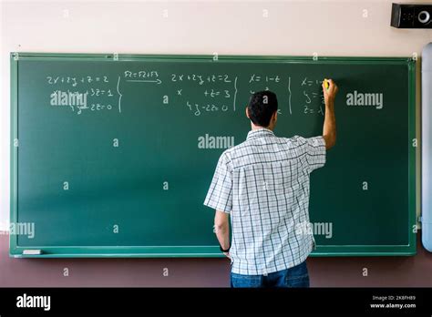 Math Teacher Writing Formulas On Chalkboard In Classroom Stock Photo Alamy