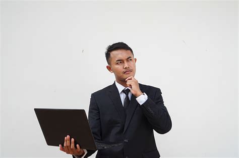 젊은 아시아 사업가가 노트북으로 작업하면서 흰색 배경에 고립된 전략에 대해 생각한다 감독에 대한 스톡 사진 및 기타 이미지 감독 질문하기 25 29세 Istock