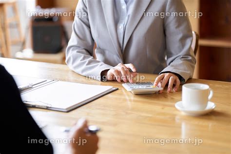 お金の話をするアジア人ビジネスウーマンの写真素材 234288864 イメージマート