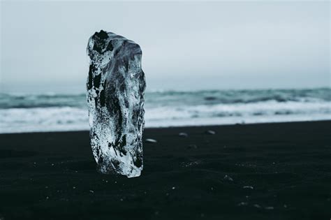 아이슬란드의 대서양의 차가운 푸른 물에 맞서 검은 모래 해변에 있는 빙하 조각 0명에 대한 스톡 사진 및 기타 이미지 0명