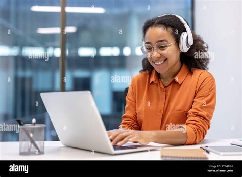 Female Programmer Wearing Headphones Coding New Software On Laptop Focused And Happy While