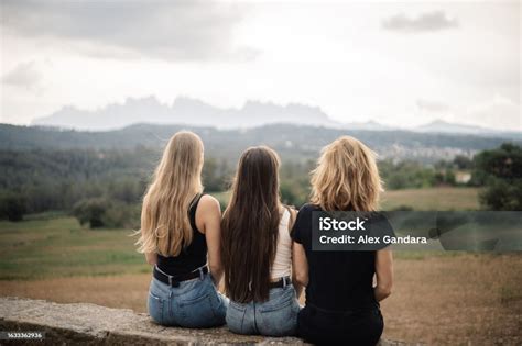 국적과 민족이 다른 세 명의 소녀가 풍경을 바라보며 앉아 회색 하늘을 가진 들판입니다 후면에 대한 스톡 사진 및 기타 이미지 후면 서 있기 소녀 Istock