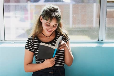 Lächelndes Mädchen liest in der Schule Kostenlose Foto
