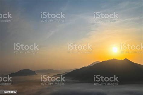 아침에 아름다운 일출 안개가 산 배경을 덮고 있는 겨울 안개가 자욱한 아름다운 봄 산골짜기와 안개 낀 산을 배경으로 한 풍경 숲