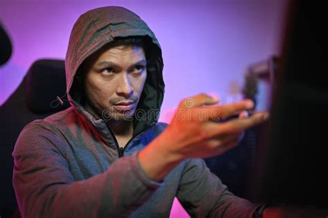 Young Adult Male In Hoodie Playing Video Games On Computer With Serious