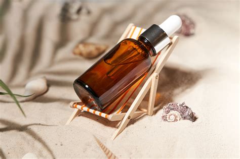 여름 자외선 차단제 본질은 조개와 바다별이 있는 모래 배경의 갑판 의자에 있습니다 B 열대 기후에 대한 스톡 사진 및 기타