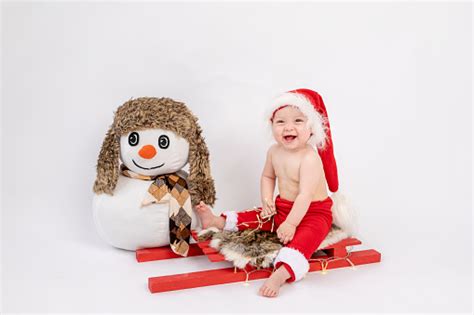 눈사람이 있는 흰색 고립된 배경에 산타 모자를 쓰고 빨간 썰매에 앉아 있는 어린 소녀 2021년 새해 복 많이 받으세요 텍스트를