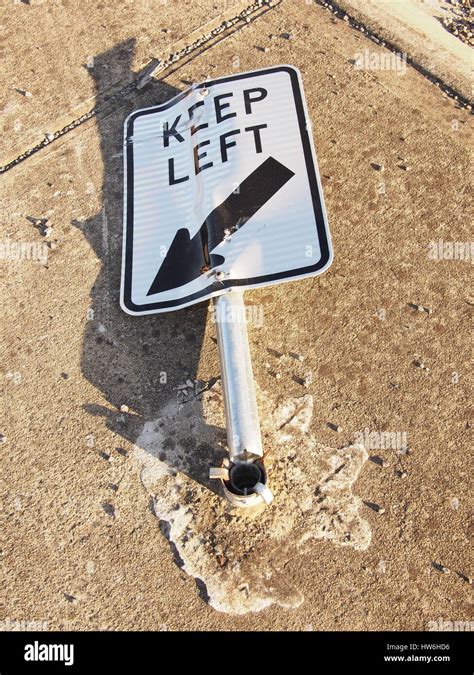 Broken Road Sign At A Traffic Island Bent To The Ground After Heavy