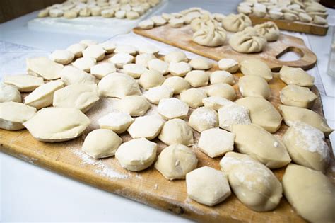 수제 만두 라비올리 킨칼리는 흰색 배경에 밀가루를 뿌린 도마위에 아름답게 배치되어 있습니다 가정 생활에 대한 스톡 사진 및 기타