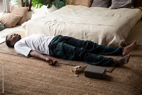 Foto De Young Black Man Lying In Dead Body Exercise Or Corpse Pose With