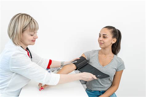 전문 여성 의사는 병실에서 젊은 여성 환자 손에 압력을 측정하기위한 장치에 넣어 2명에 대한 스톡 사진 및 기타 이미지 2명