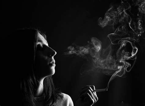 Premium Photo Close Up Of Woman Smoking Cigarette Over Black Background