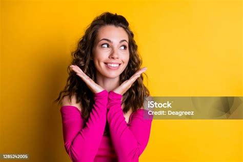 사진 달콤한 이빨 곱슬 여자 친구 보기 측면 빈 공간 팔 손바닥 얼굴 착용 밝은 분홍색 오프 어깨 상단 고립 된 생생한 노란색 색상 배경 갈색 머리에 대한 스톡 사진 및