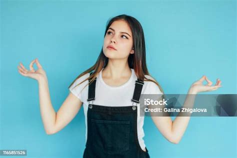 파란색 배경에 고립 된 흰색 티셔츠에 어두운 긴 머리를 가진 매력적인 명상 소녀 T 셔츠에 대한 스톡 사진 및 기타 이미지