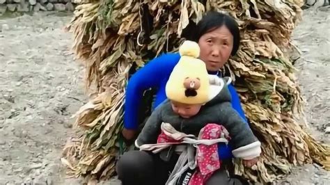 农村在家留守的妇女她的手里抱着宝宝背上还要背一大捆柴火 腾讯视频