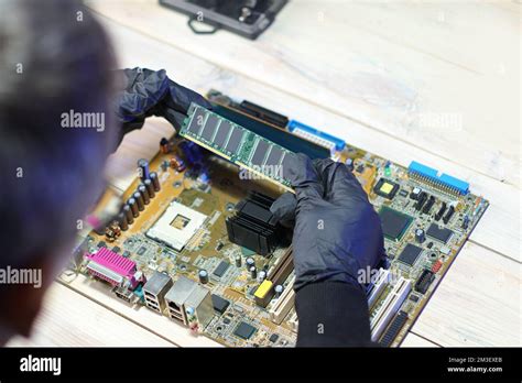 Inserting Ram Into Motherboard From Computer On Table And Gray