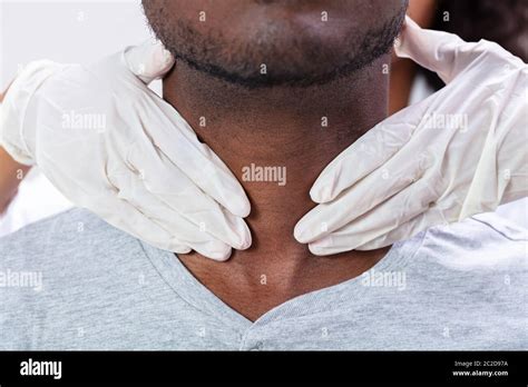 Doctor Performing Physical Exam Palpation Of The Thyroid Gland Stock