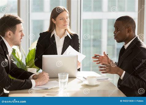 Multi Ethnic Business Team Discussing Project Idea Sitting At Of Stock