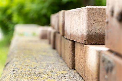 이끼가 있는 밝은 회색 콘크리트 벽에 적갈색 벽돌을 닫습니다 거친 질감과 엇갈린 패턴 흐릿한 정원 배경 0명에 대한 스톡 사진 및 기타 이미지 Istock