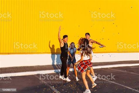 아름 다운 멋진 젊은 점프와 함께 색종이 노란색 배경에 영의 그룹 사람들이 축 하 하 고 재미 여름 분위기 장소 도시에서 산책 친구 라이프 스타일 주차장에서 파티 대학교에