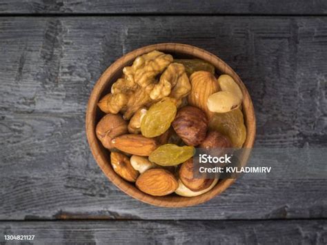 검은 나무 테이블에 견과류와 말린 과일이 혼합 된 나무 그릇 상단에서 보기입니다 0명에 대한 스톡 사진 및 기타 이미지 0명