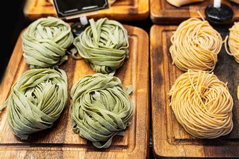 시금치와 구운 야채 타르트 와 녹색 Tagliatelle 가게에서 나무 트레이에 클로즈업 이탈리안 생 파스타 채식 요리 0명에