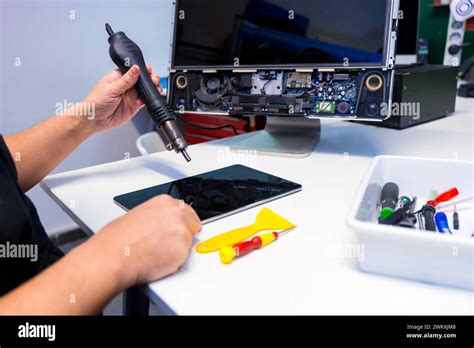 Side View Of An Unrecognizable Technician Fixing A Computer Component