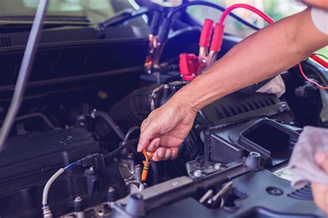 오픈 후드와 정비사 수리 자동차 오픈 후드와 차에 정비사 검사 레벨 모터 오일의 측면보기 배터리의 전압을 확인하기 위한 흐릿한 볼트미터 검사 보기에 대한 스톡 사진 및 기타