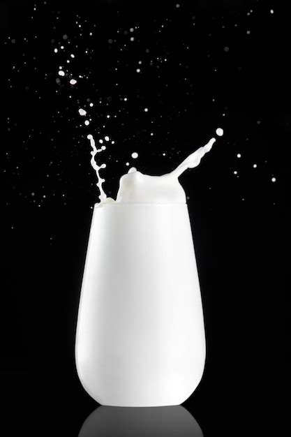 Premium Photo Splashes And Drops Of Milk Glass On Black Background