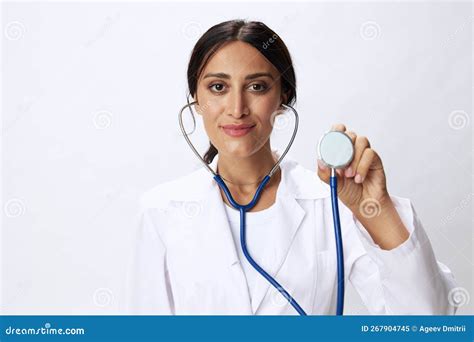 Woman Doctor With Stethoscope In Hand In Medical Gown On White Nurse