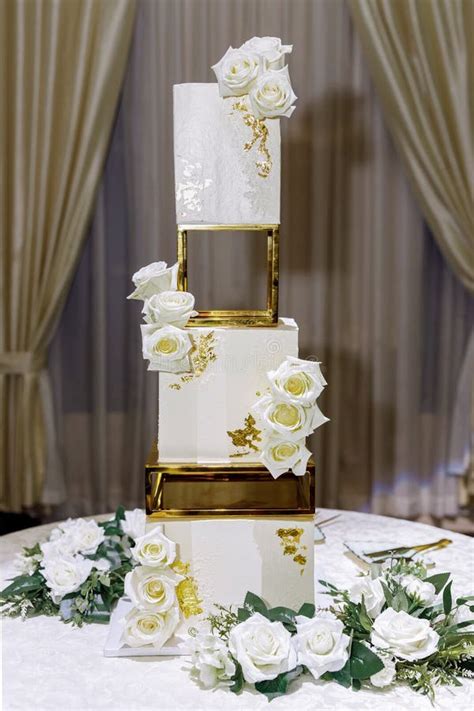 Gorgeous Multi Tiered Wedding Cake Decorated With Gold And White Roses