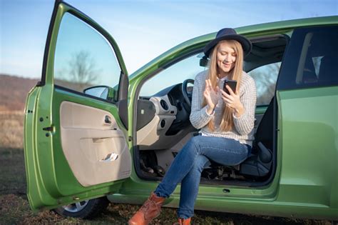 손에 스마트 폰 지역 여행 및 모험 개념에 앉아있는 동안 시골에서 자동차로 여행 모자를 쓰고 아름다운 젊은 여성 관광에 대한 스톡 사진 및 기타 이미지 Istock