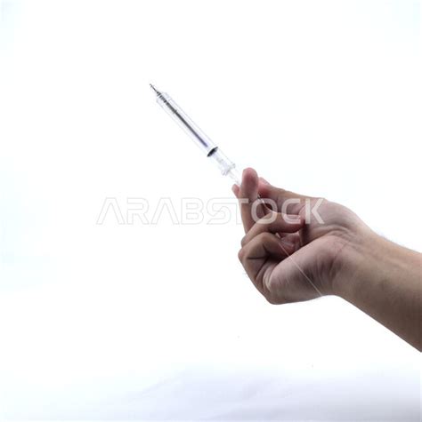 صورة مقربة ليد تمسك إبره طبيه، تطعيم، تجهيز الحقنة، معدات وأدوات طبية