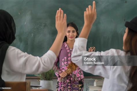 아름다운 말레이시아 교사는 학교에서 전통적인 천을 입고 학생은 손을 올립니다 고등학교에 대한 스톡 사진 및 기타 이미지 고등