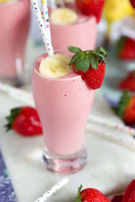 Strawberry Banana Smoothie In A Tall Glass With A Banana Slice On Top