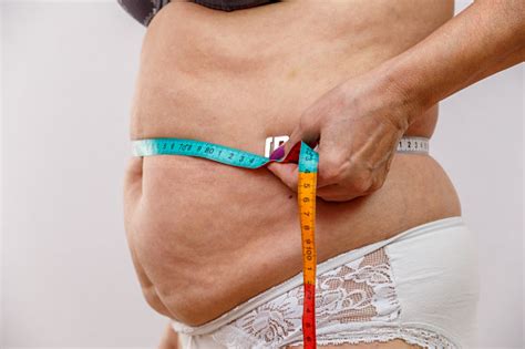 그녀의 시체를 측정 하는 노인 여성 밝은 회색 배경에 고립 의학 및 미용에 대 한 개념 과체중에 대한 스톡 사진 및 기타 이미지