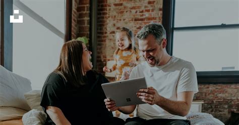 침대에 앉아 태블릿을 보고 있는 남자와 여자 사진 Unsplash의 무료 전자공학 이미지